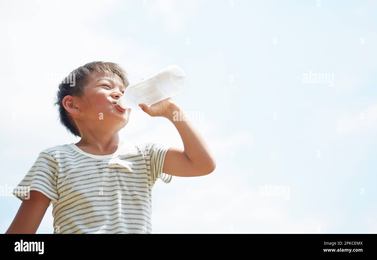 Sweaty boy drinking water Stock Photo - Alamy