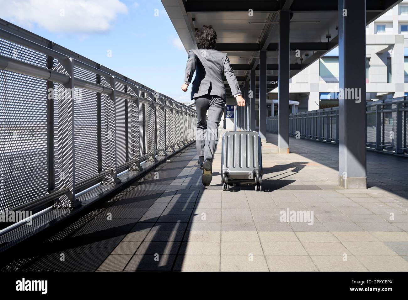 office worker pulling a carrying case while running Stock Photo - Alamy