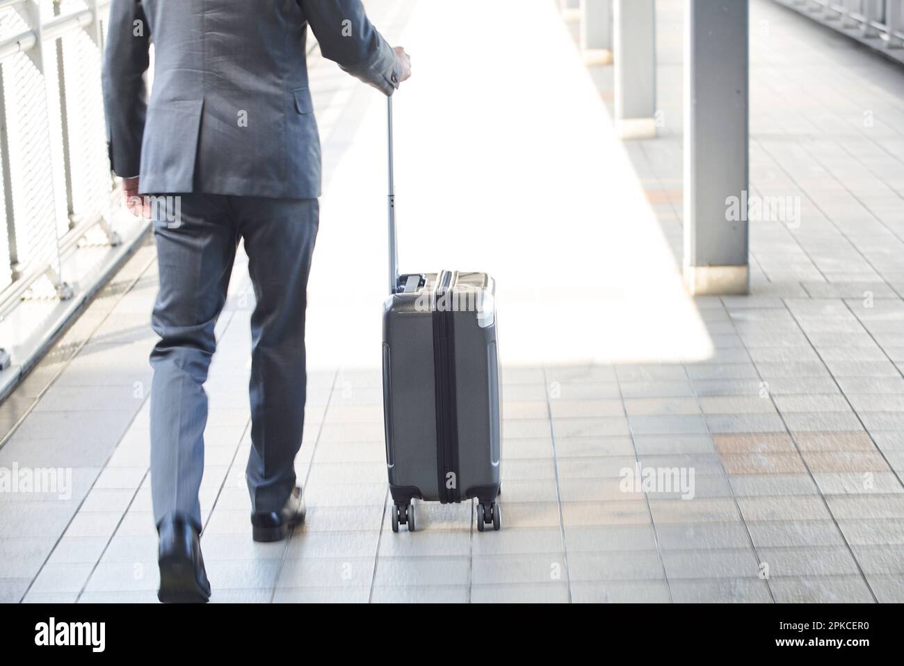 Office worker pulling a carrying case Stock Photo - Alamy