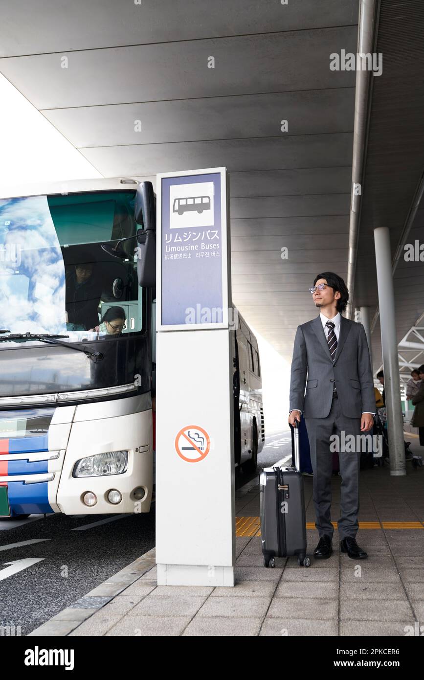 A businessman waiting at a bus stop Stock Photo - Alamy
