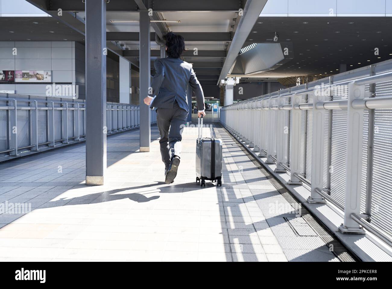 office worker pulling a carrying case while running Stock Photo - Alamy