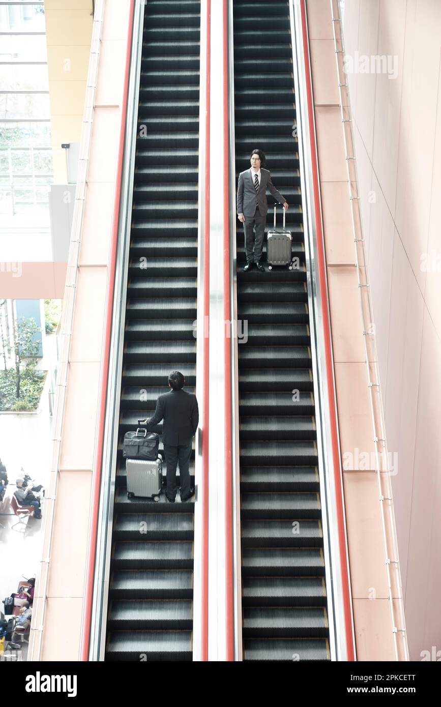 Office worker riding on the escalator Stock Photo - Alamy