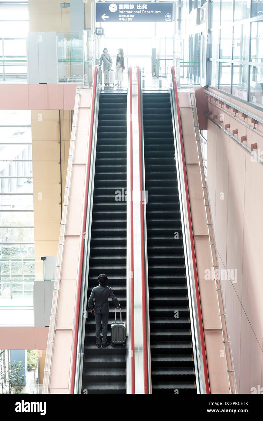 Office worker riding on the escalator Stock Photo - Alamy
