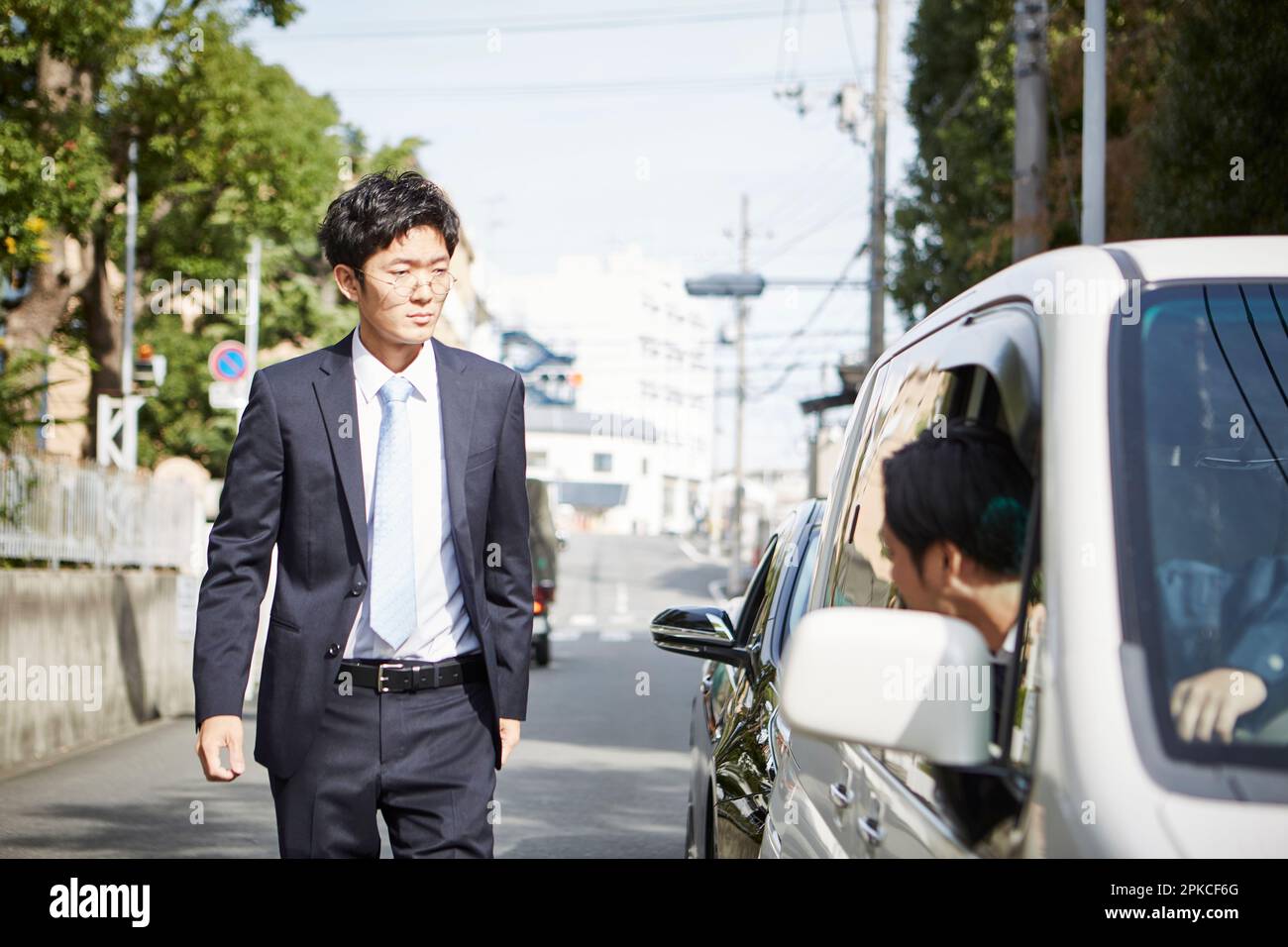 Man with a grim expression and man looking out of car window Stock ...