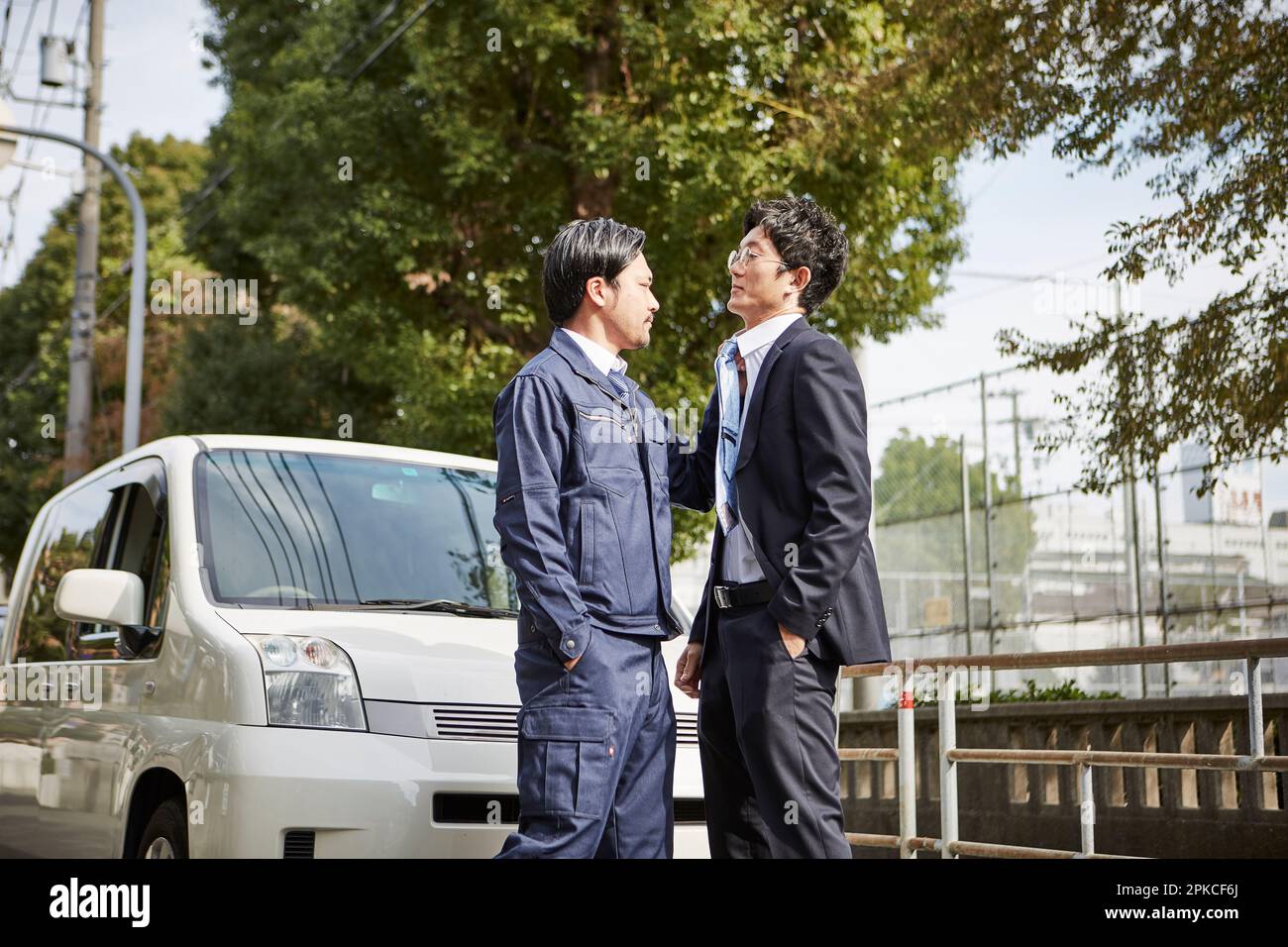 Two men tense in front of car Stock Photo - Alamy