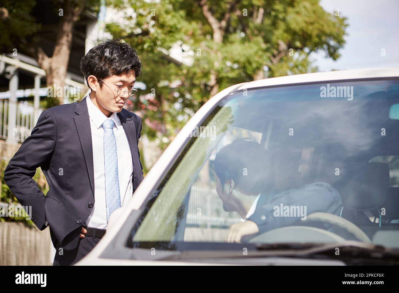 Steely looking man and man looking out of car window Stock Photo - Alamy