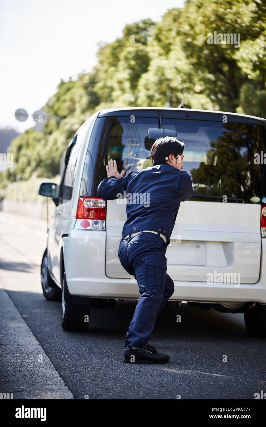 Man pushing a white car Stock Photo - Alamy