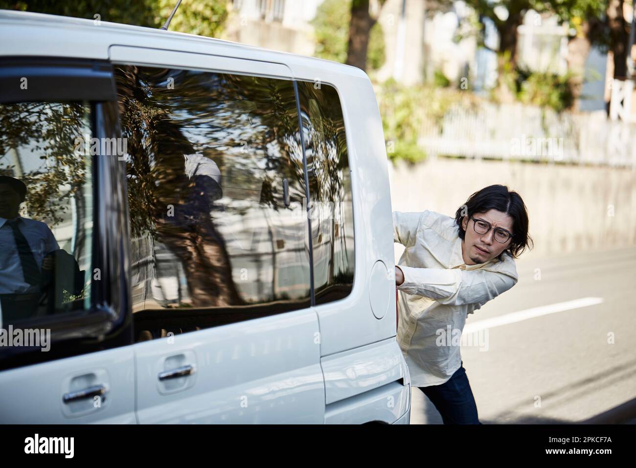 Man pushing a white car Stock Photo - Alamy