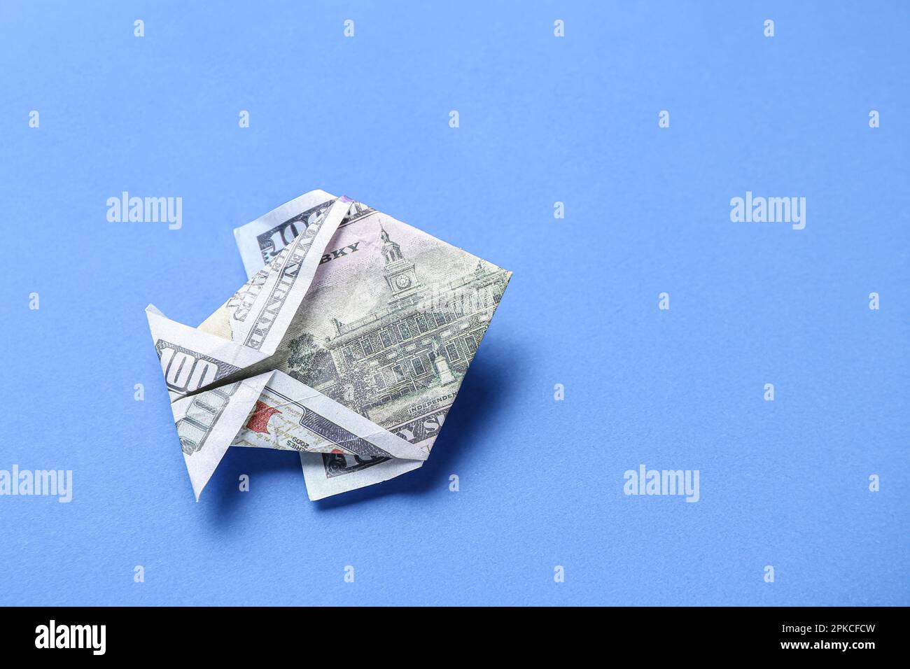 Origami fish made of dollar banknote on blue background Stock Photo - Alamy