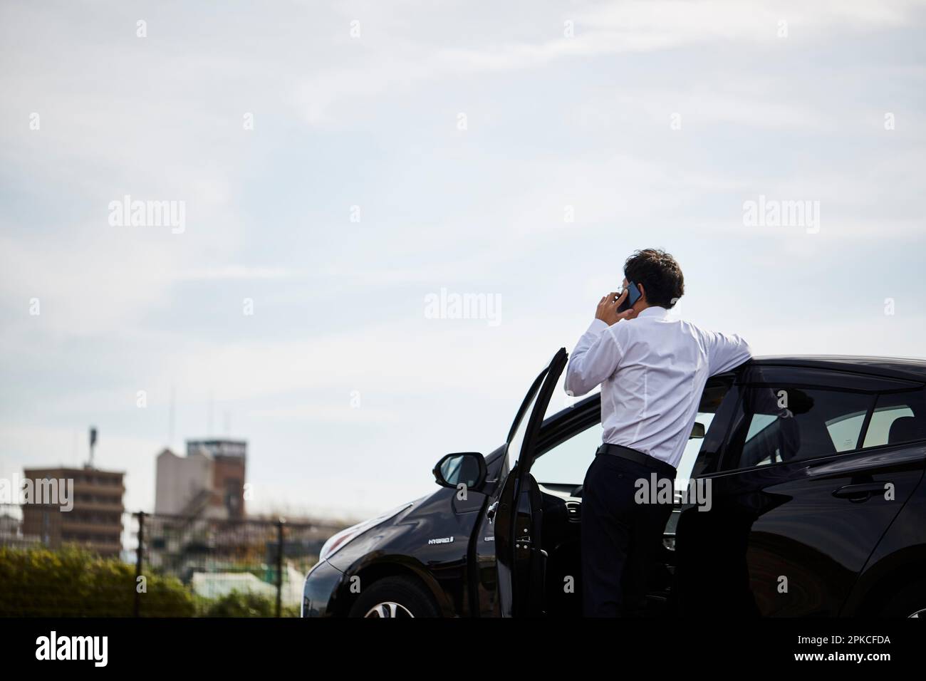 Back view of man making a phone call standing next to his car Stock ...