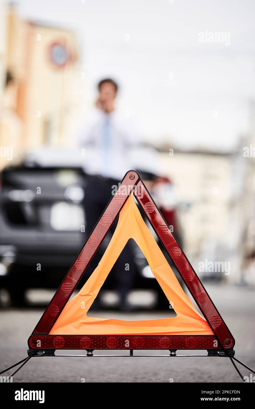 Man making a phone call with triangular sign Stock Photo - Alamy