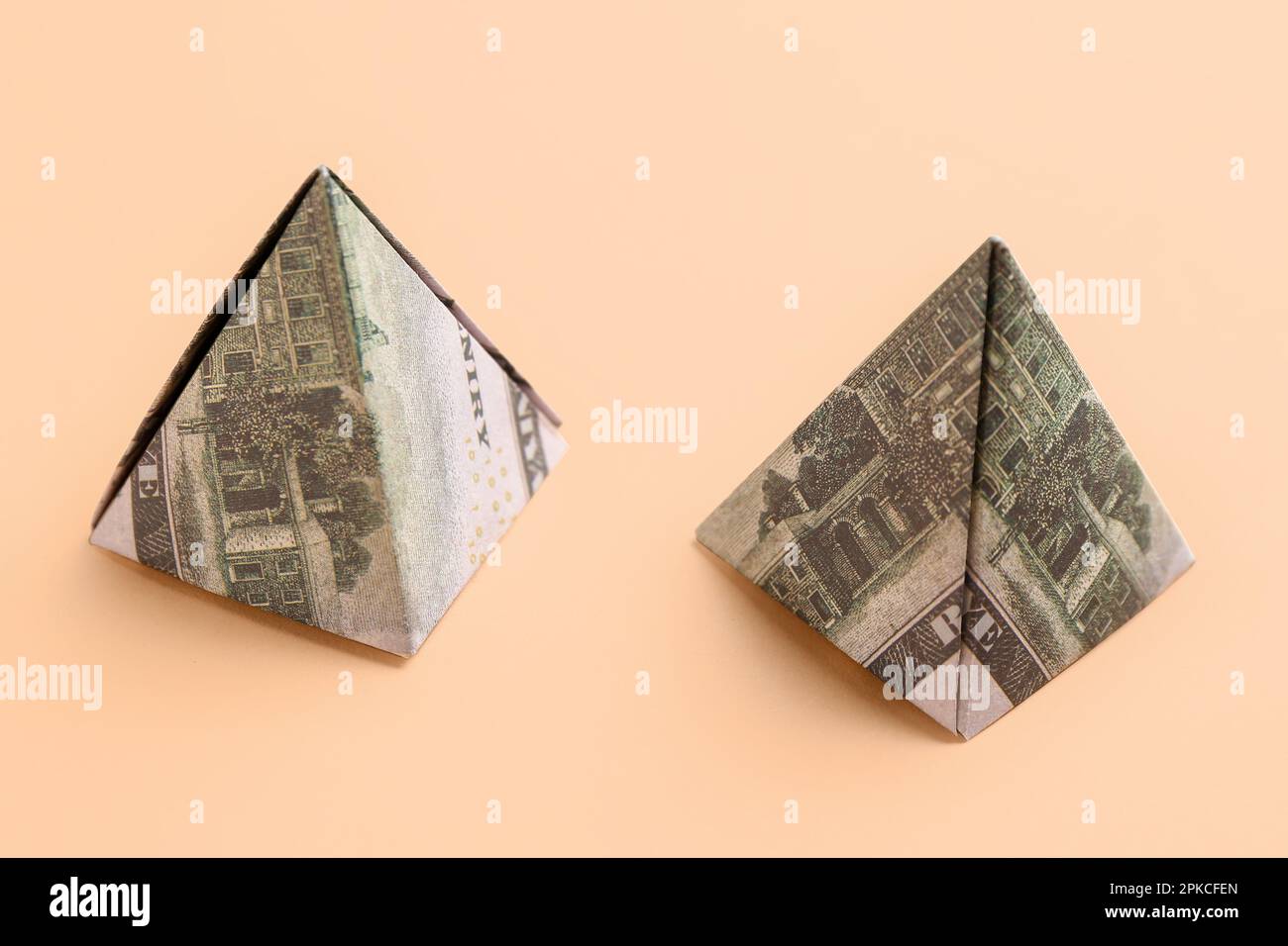 Origami pyramids made of dollar banknotes on beige background Stock ...