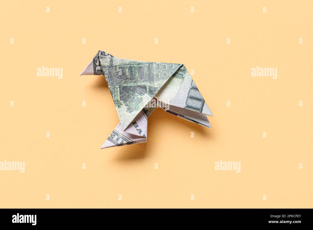 Origami bird made of dollar banknotes on beige background Stock Photo ...