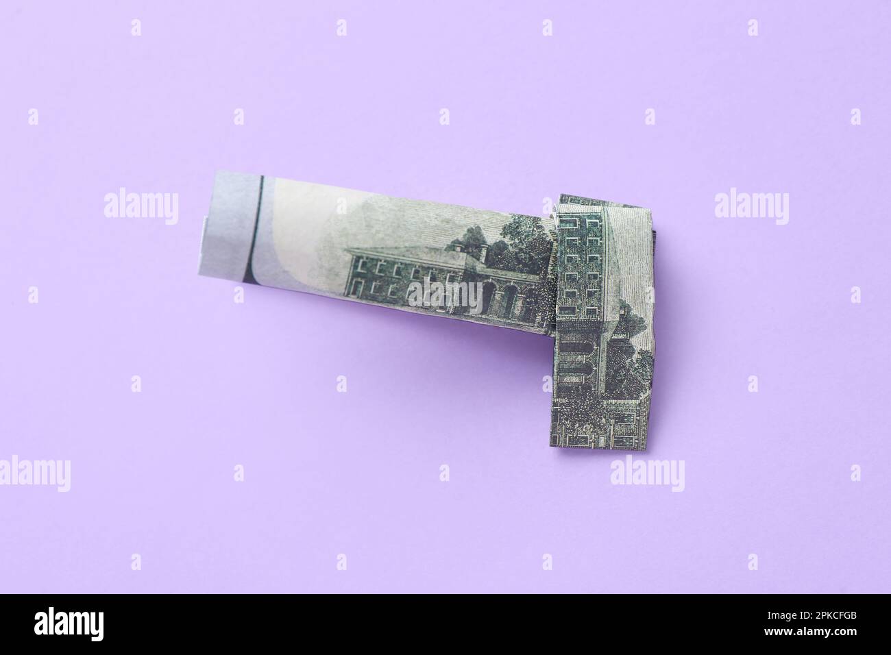 Origami gun made of dollar banknotes on lilac background Stock Photo ...