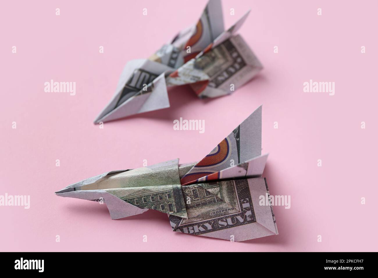 Origami airplanes made of dollar banknotes on pink background Stock ...