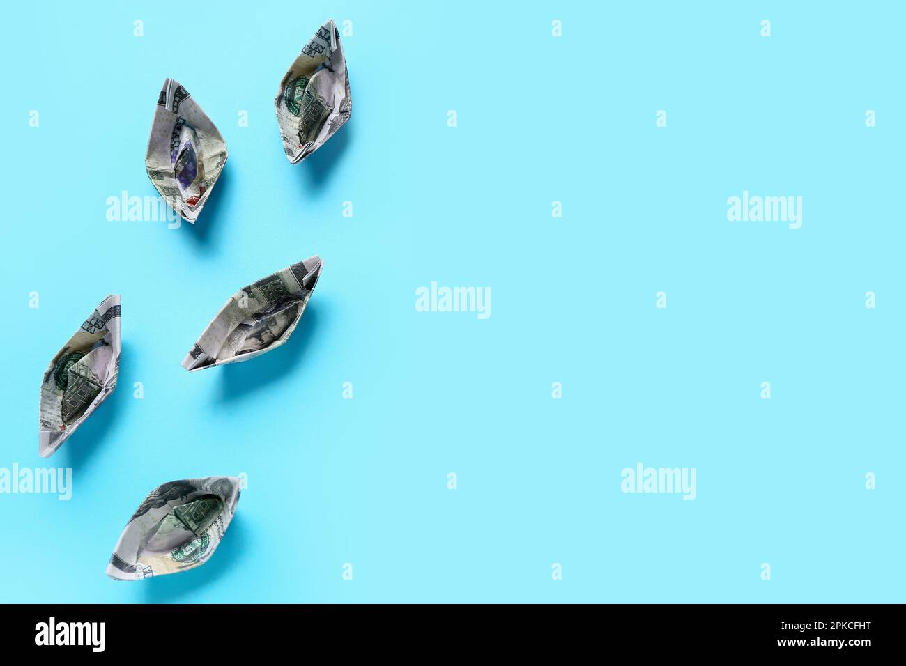 Origami boats made of dollar banknotes on blue background Stock Photo ...