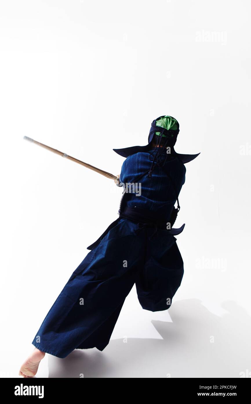 Back view of a man wearing a kendo gown swinging a bamboo sword Stock ...