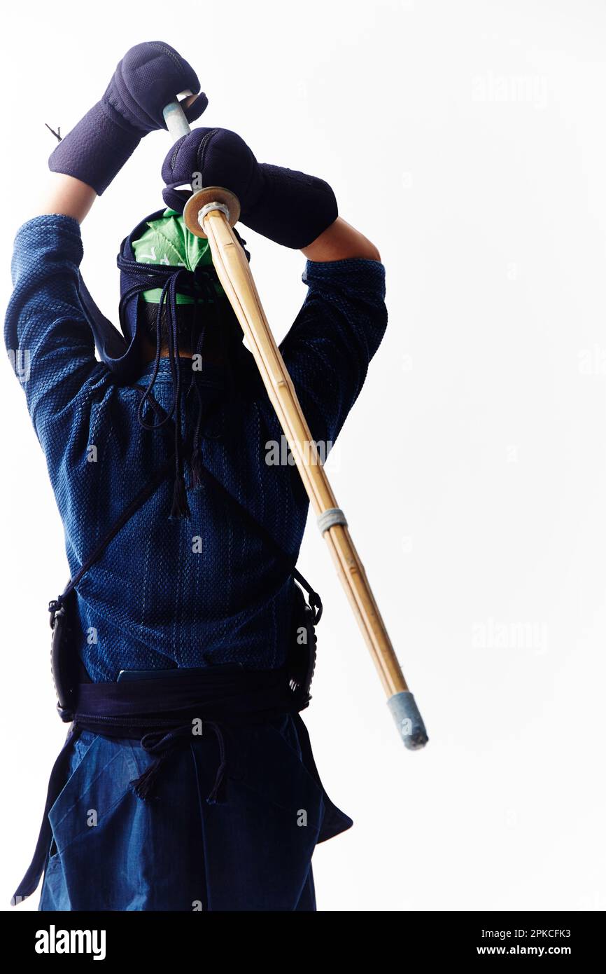 Back view of a man wearing a kendo gown swinging a bamboo sword Stock ...
