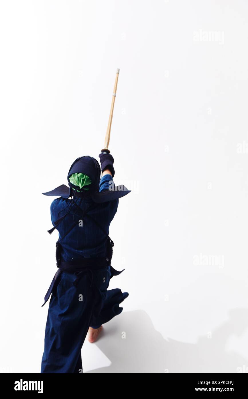 Back view of a man wearing a kendo gown swinging a bamboo sword Stock ...