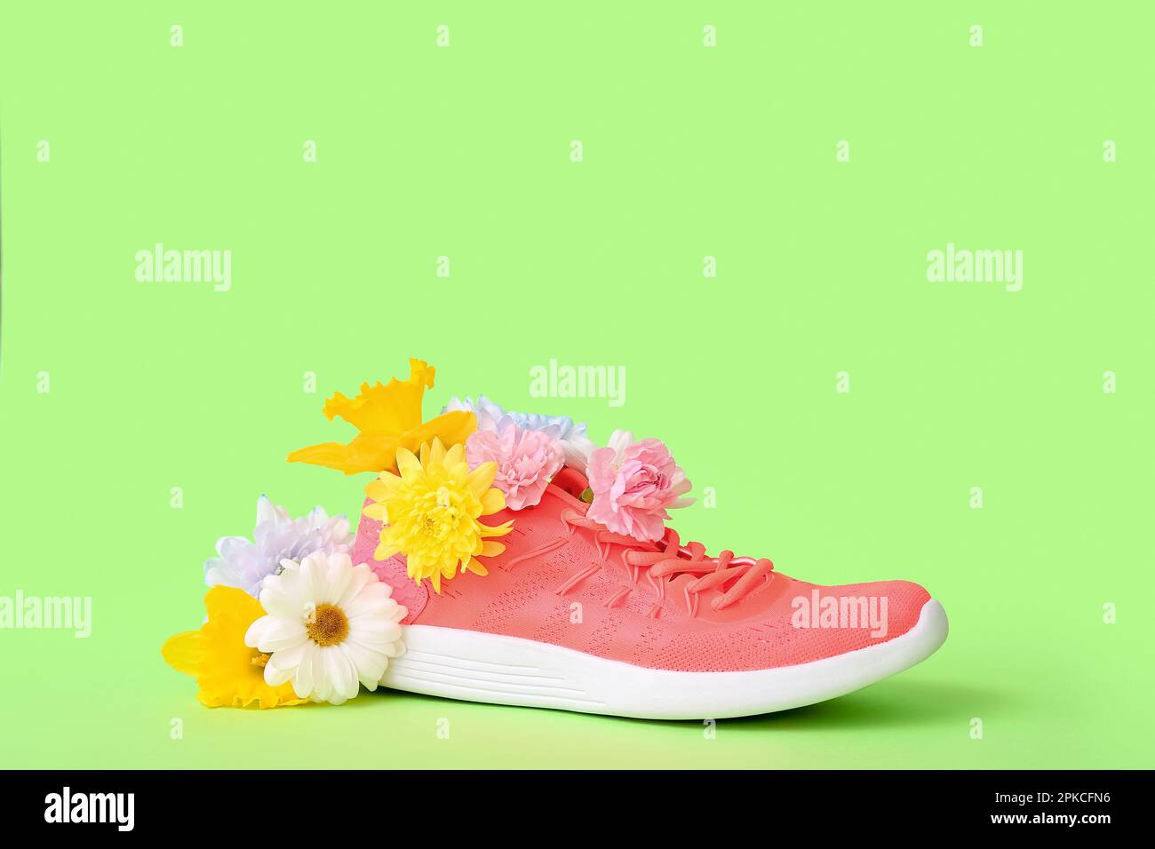 Sneaker with spring flowers on green background Stock Photo - Alamy