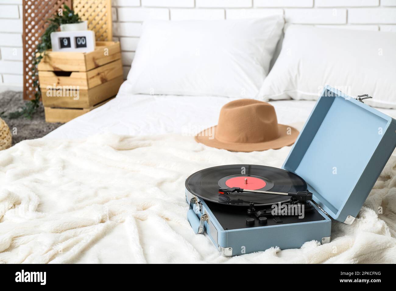 Record player with vinyl disk on bed in room Stock Photo - Alamy