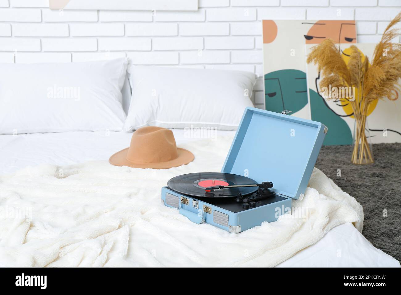 Record player with vinyl disk on bed in room Stock Photo - Alamy