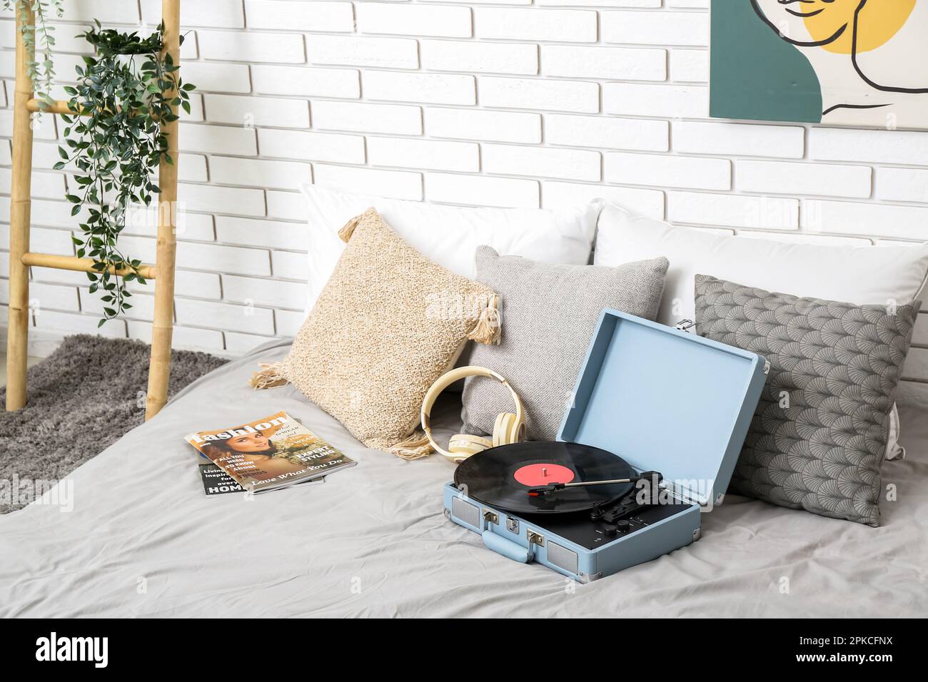 Record player with vinyl disk and headphones on bed in room Stock Photo ...