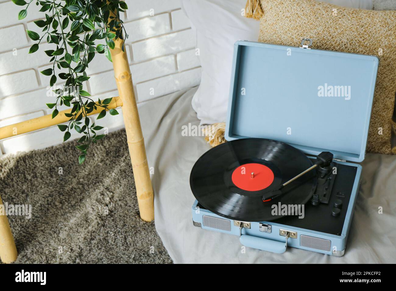 Record player with vinyl disk on bed in room Stock Photo - Alamy
