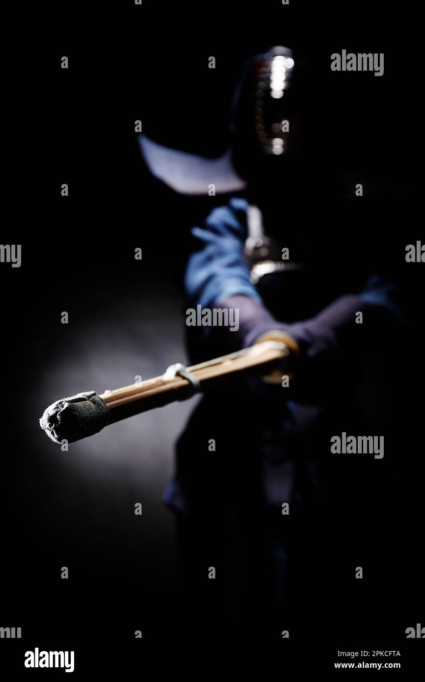 A man wearing a do-gi swinging a bamboo sword down Stock Photo - Alamy