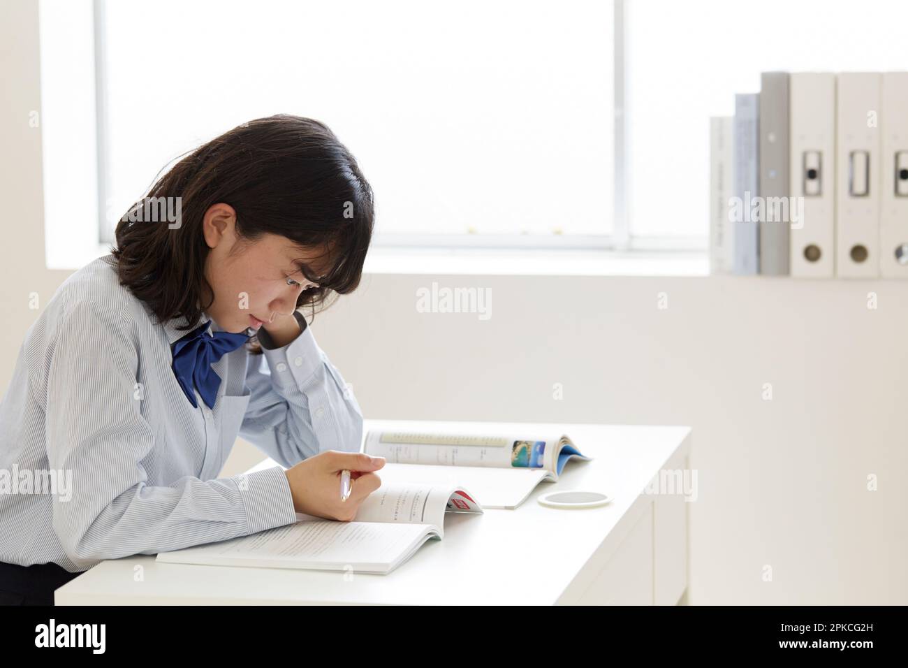 High school girl studying at a white desk Stock Photo - Alamy
