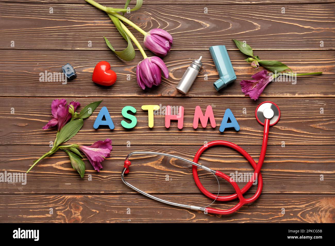 Word ASTHMA with inhaler, stethoscope, heart and flowers on wooden ...