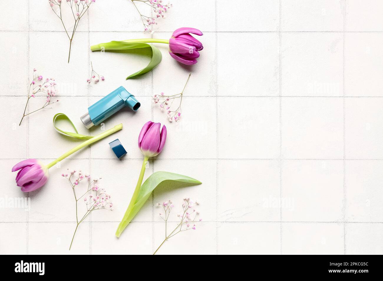 Asthma inhaler with flowers on white tile background Stock Photo - Alamy