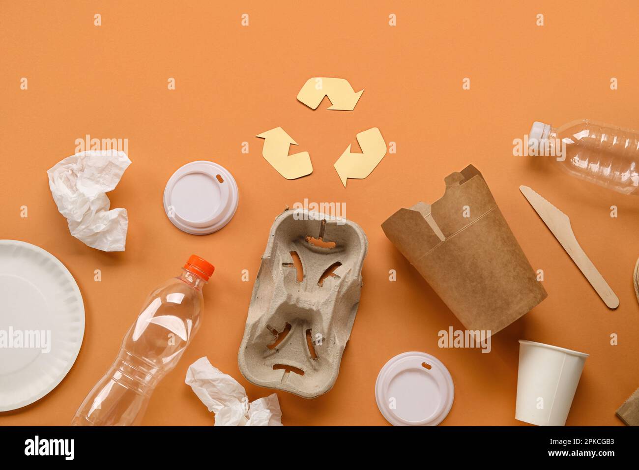 Recycling sign with garbage on orange background Stock Photo - Alamy