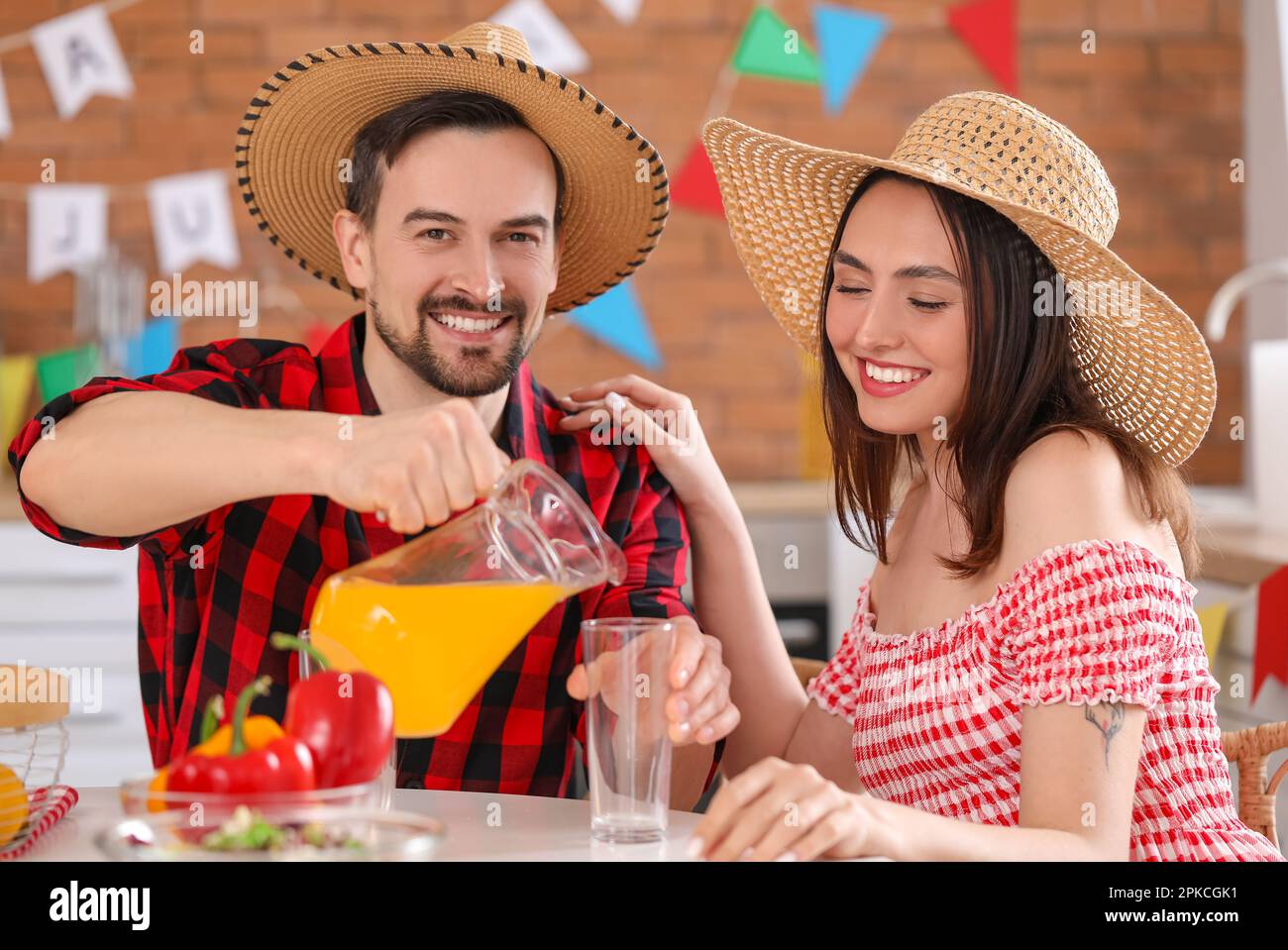 Young couple with juice celebrating Festa Junina (June Festival) in ...