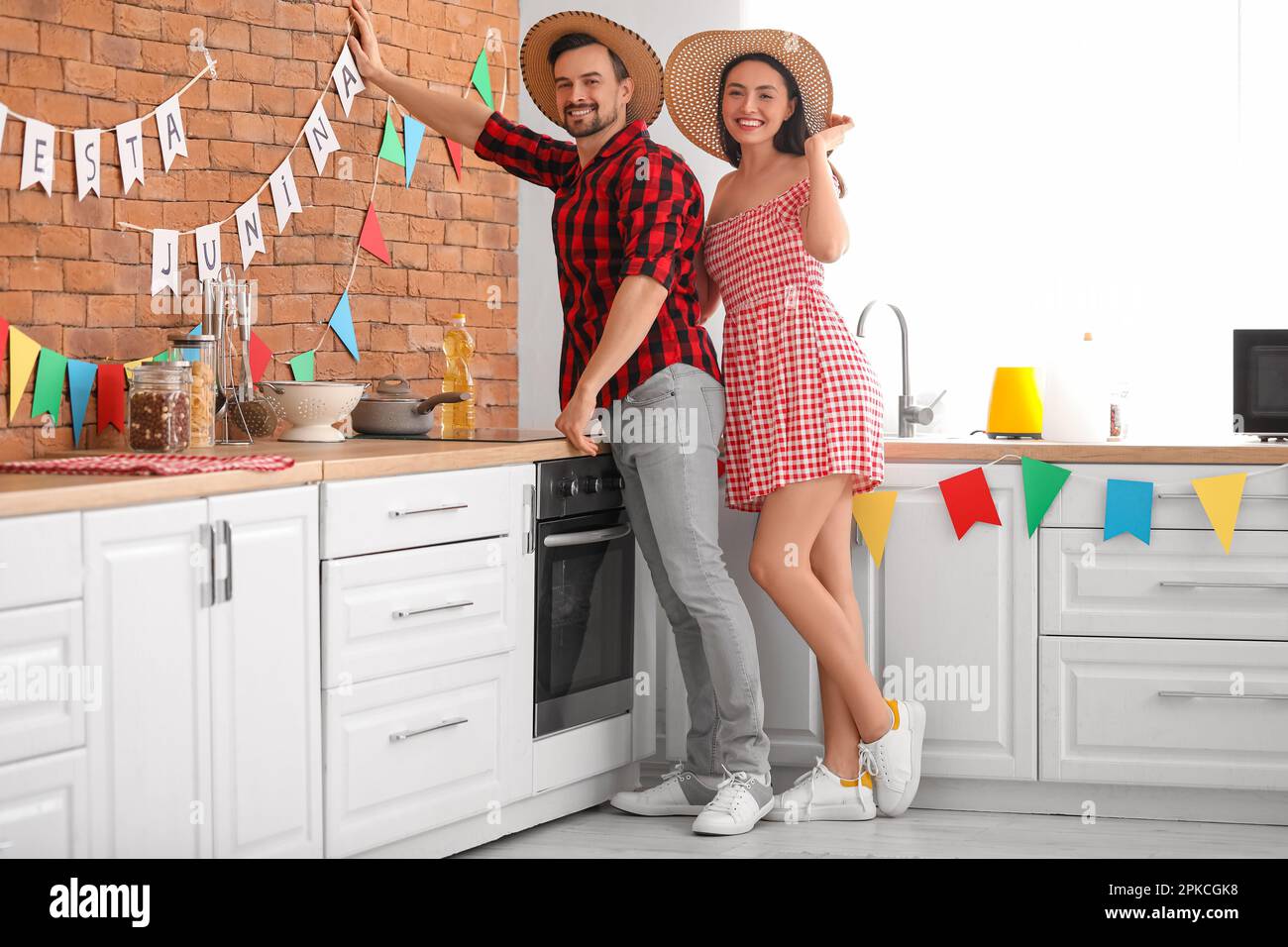 Young couple decorating kitchen with flags for Festa Junina (June ...
