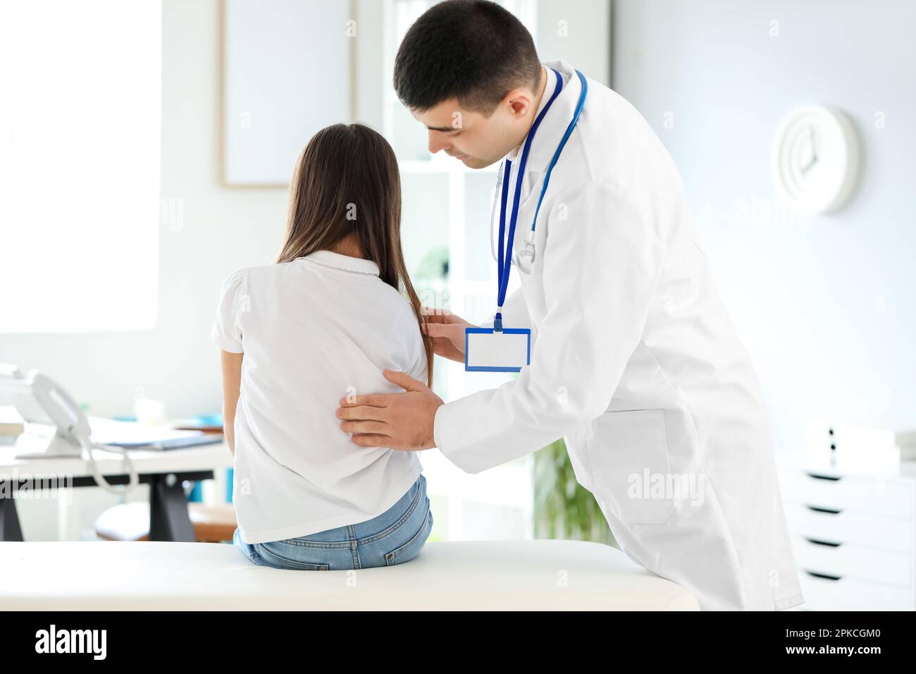 Doctor checking posture of little girl in clinic Stock Photo - Alamy