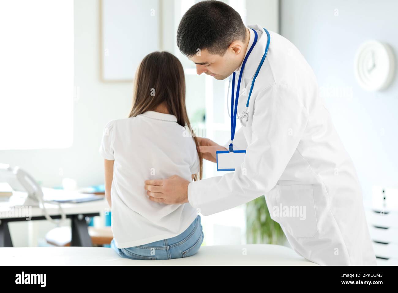 Doctor checking posture of little girl in clinic Stock Photo - Alamy
