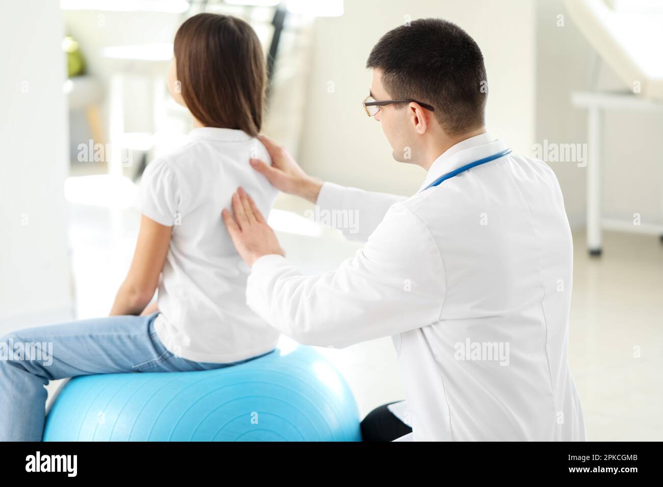 Doctor checking posture of little girl in clinic Stock Photo - Alamy