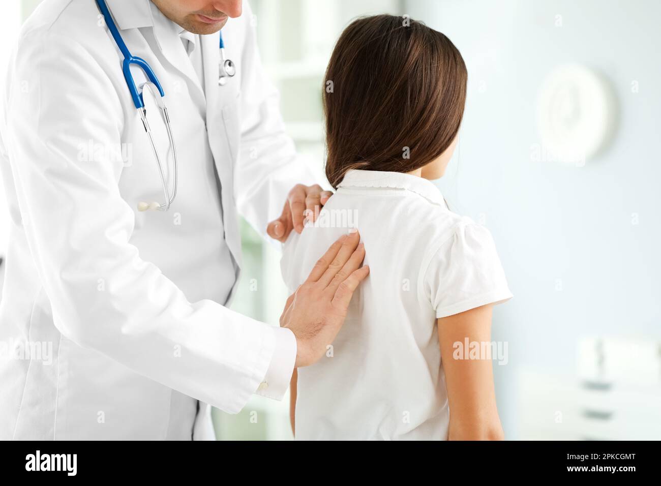 Doctor checking posture of little girl in clinic Stock Photo - Alamy