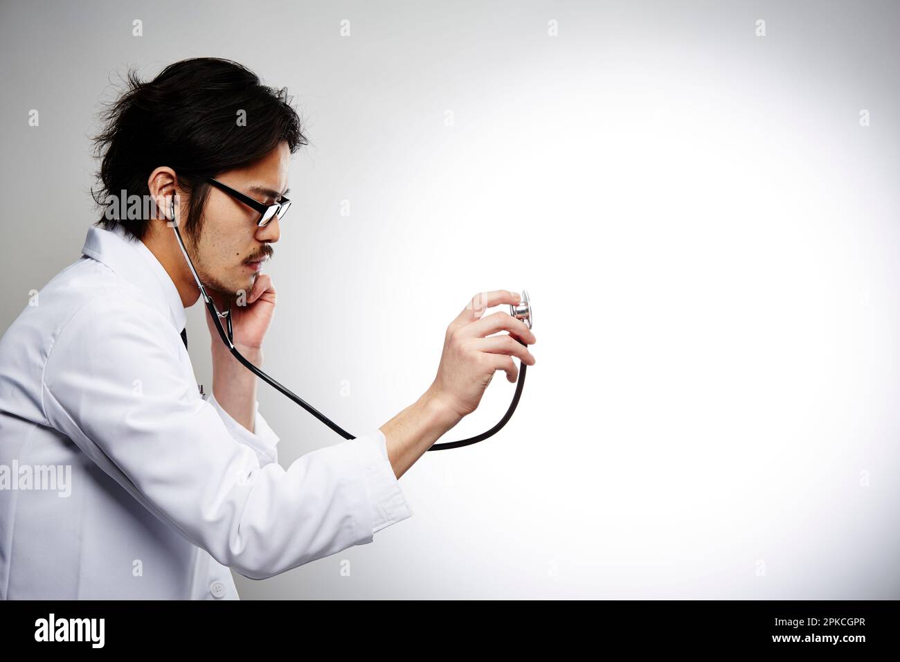 Side view of male doctor applying stethoscope Stock Photo - Alamy