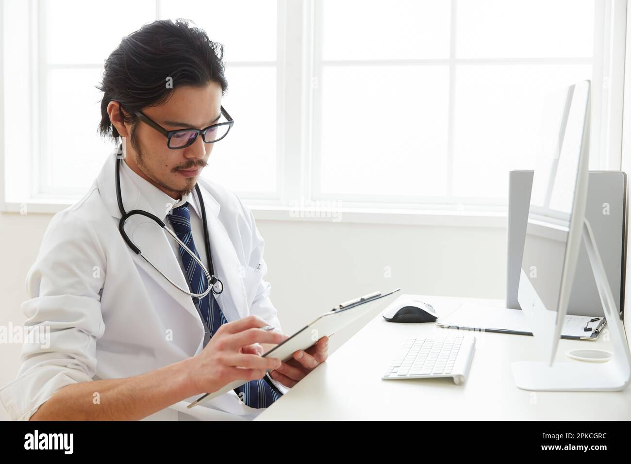 A male doctor writing in a chart Stock Photo - Alamy