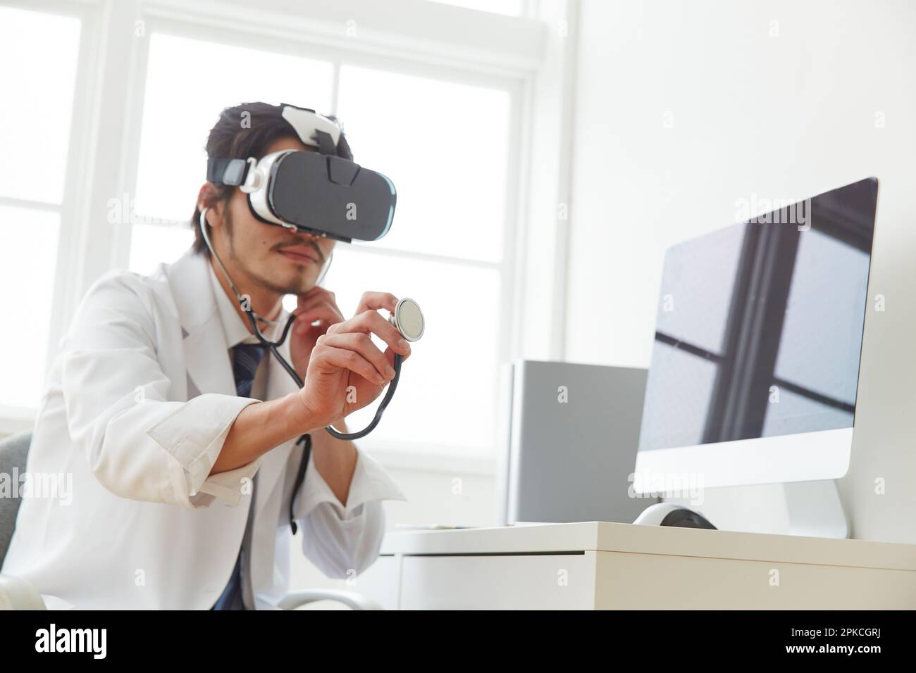 A male doctor wearing VR goggles and applying a stethoscope Stock Photo ...