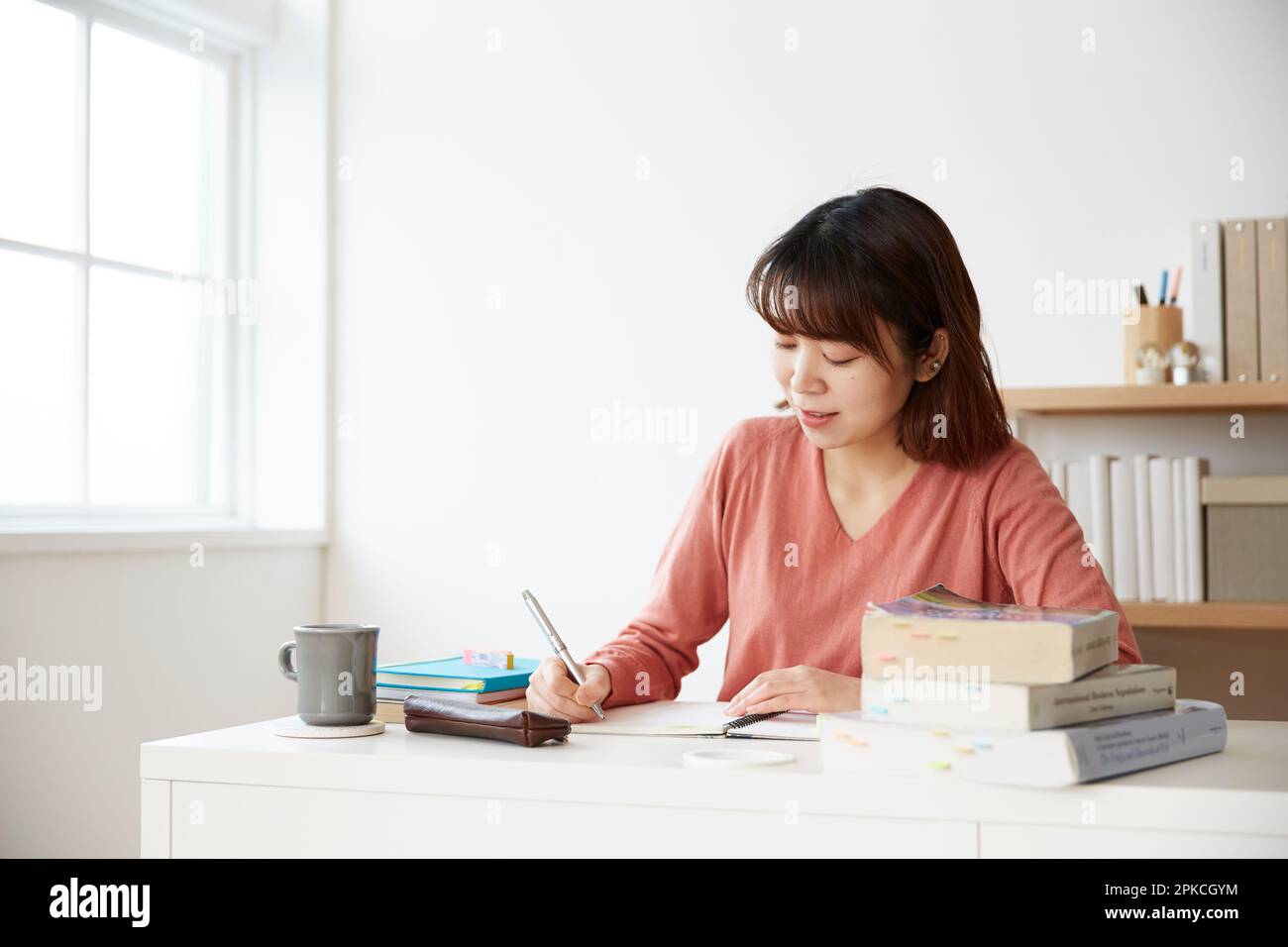 Woman studying at desk Stock Photo - Alamy