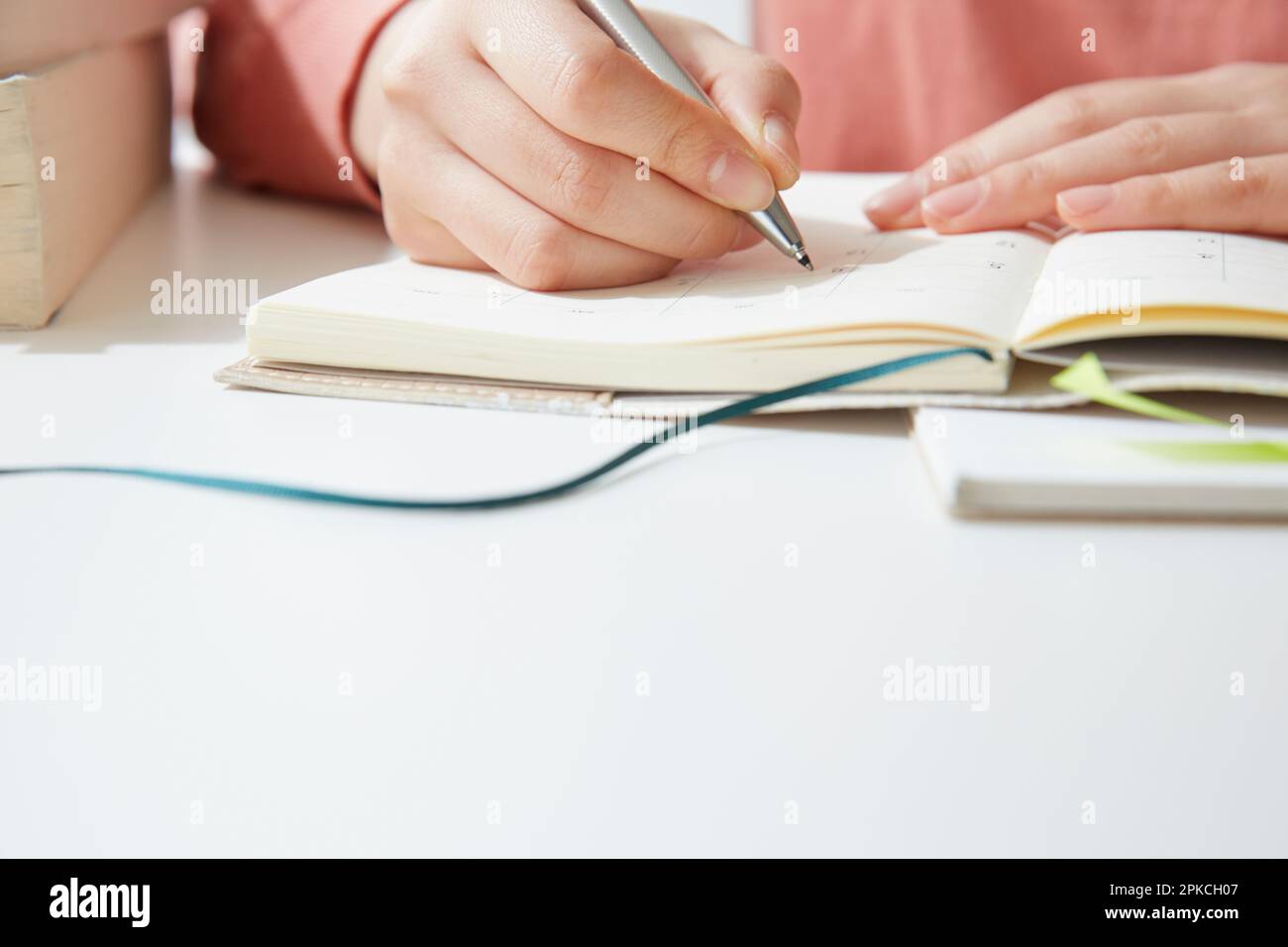 Woman's hand writing at her desk Stock Photo - Alamy