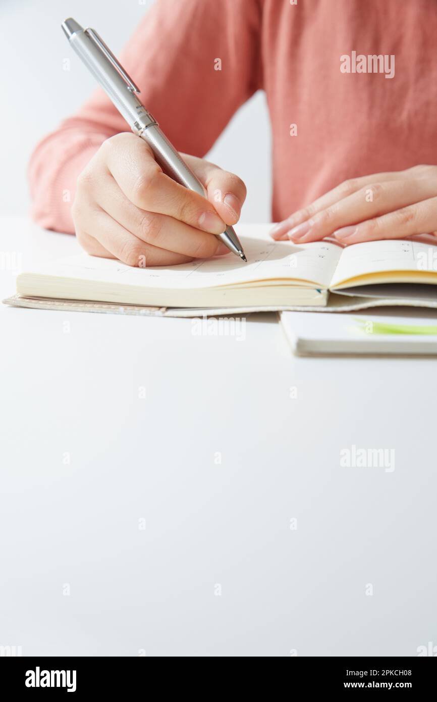 Woman's hand writing at her desk Stock Photo - Alamy