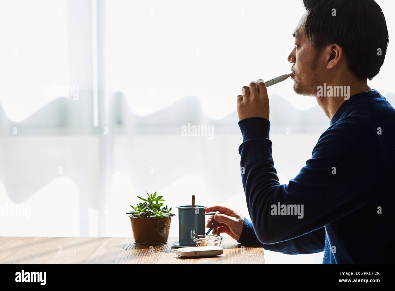 Man smoking an Icos at a café Stock Photo - Alamy