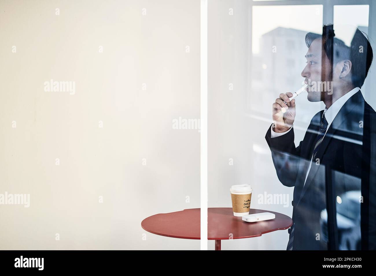Office worker smoking an Icos in a smoking room Stock Photo - Alamy