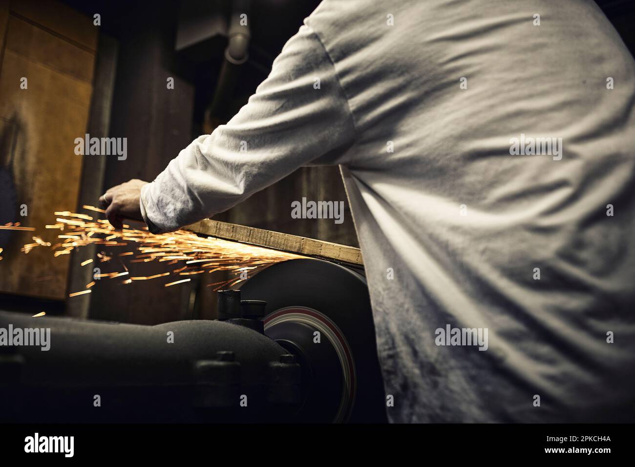 A man working with sparks in a cutlery factory Stock Photo - Alamy
