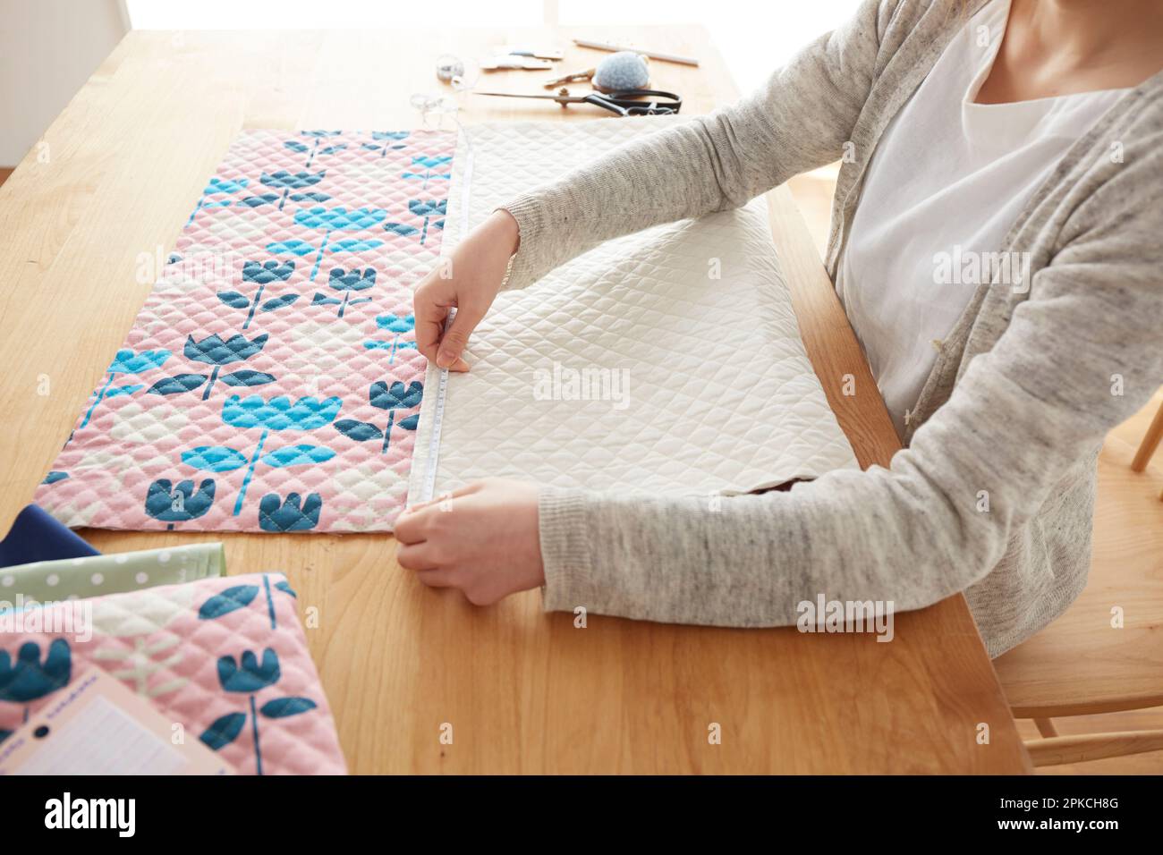 Woman measuring cloth on a natural table Stock Photo - Alamy