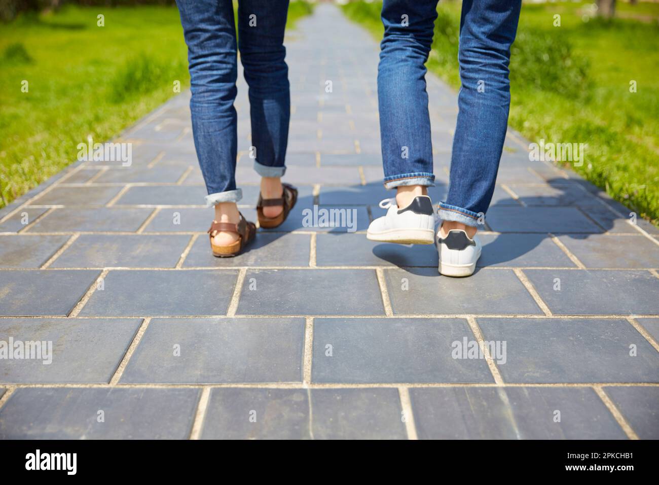 Footsteps of man and woman walking along a tiled path Stock Photo - Alamy